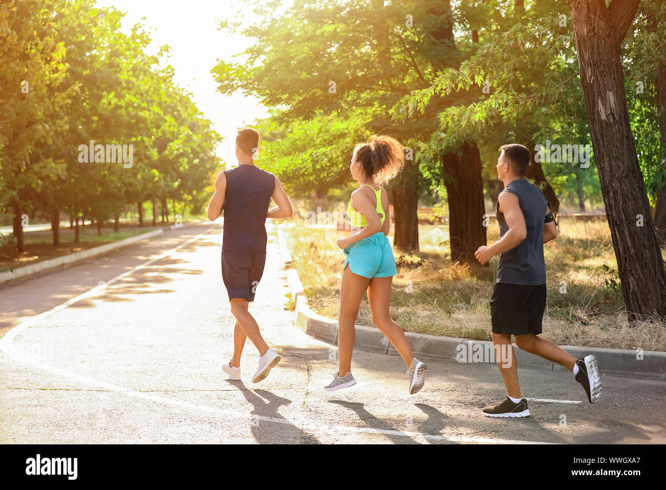 Group of sporty young people running outdoors Stock Photo - Alamy