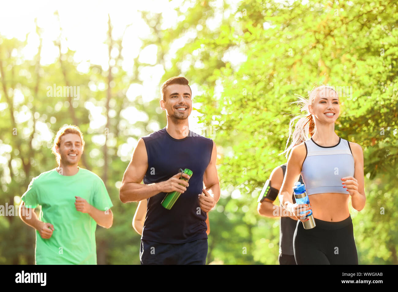 Group of sporty young people running outdoors Stock Photo - Alamy