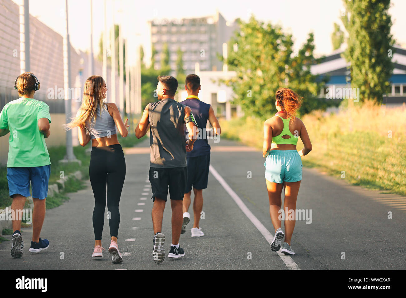 Group of sporty young people running outdoors Stock Photo - Alamy