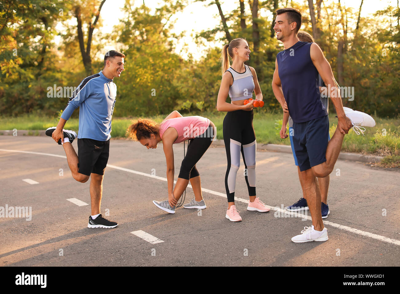 Group of sporty young people training outdoors Stock Photo - Alamy