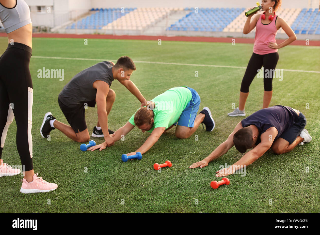 Group of sporty young people with coach training at the stadium Stock ...