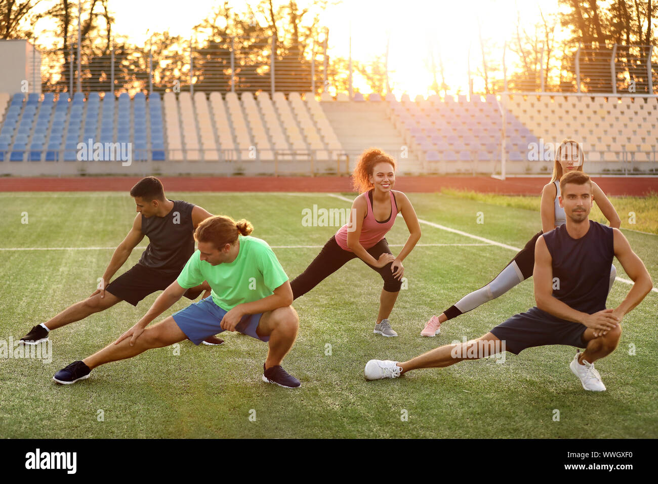 Group of sporty young people training at the stadium Stock Photo - Alamy