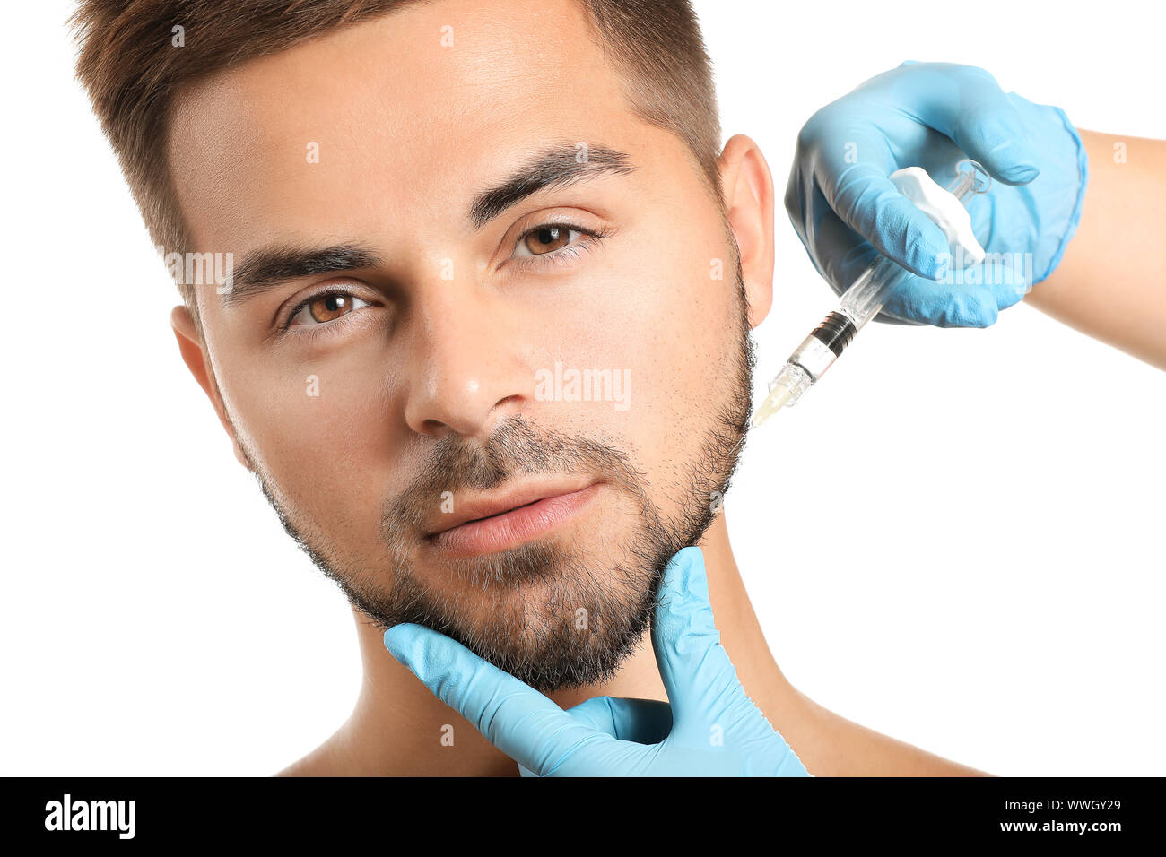 Handsome man receiving filler injection on white background Stock Photo ...