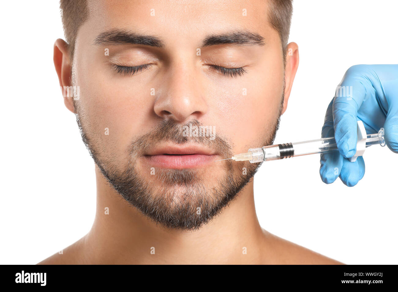Handsome man receiving filler injection on white background Stock Photo ...