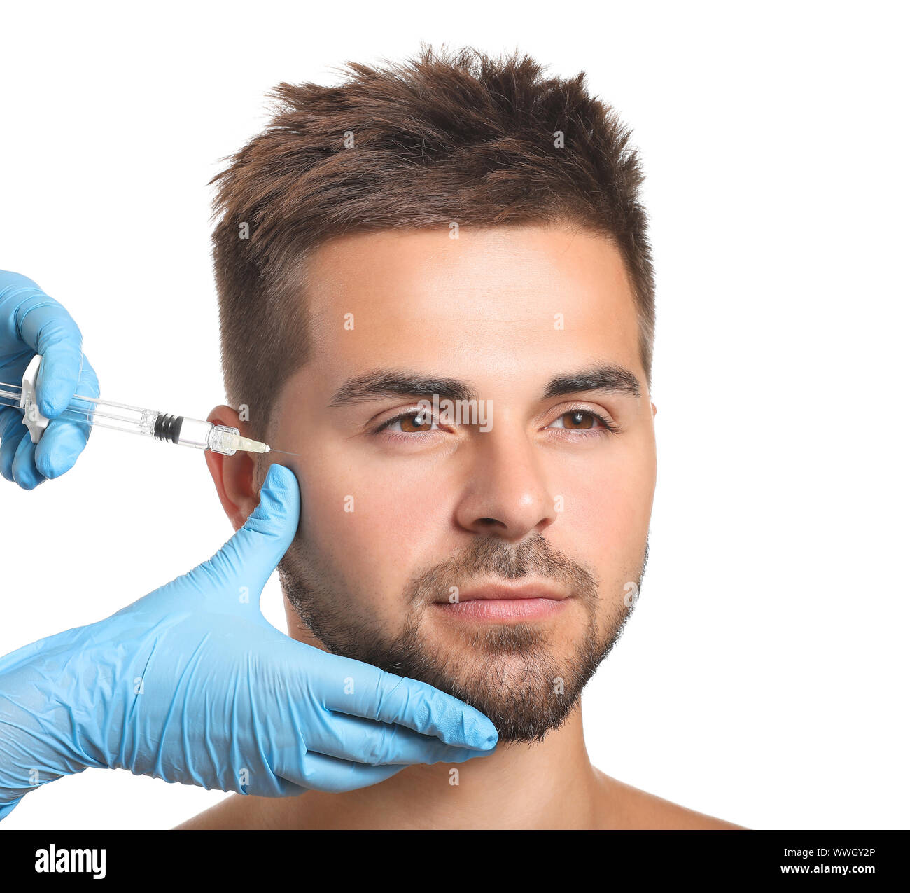 Handsome man receiving filler injection on white background Stock Photo ...