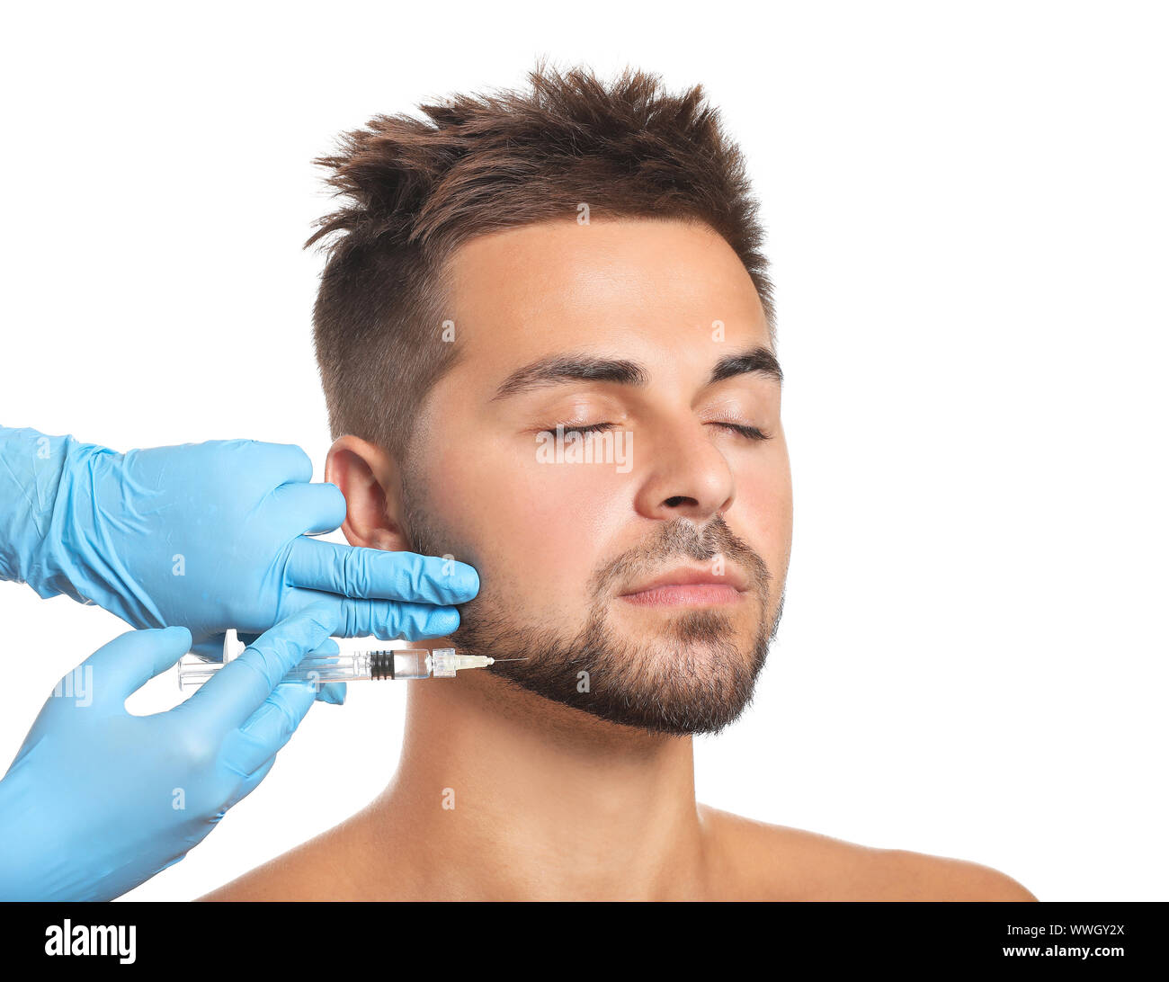Handsome man receiving filler injection on white background Stock Photo ...