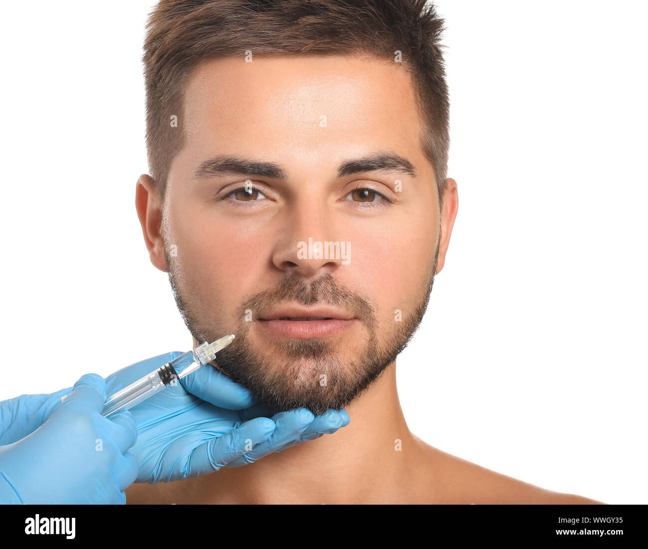Handsome man receiving filler injection on white background Stock Photo ...
