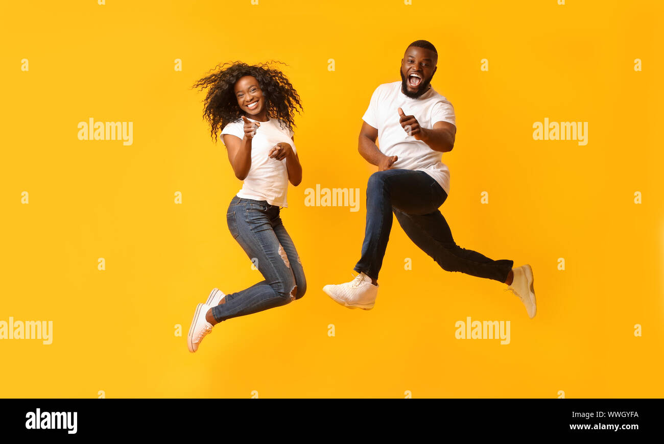Happy african couple jumping in the air Stock Photo - Alamy