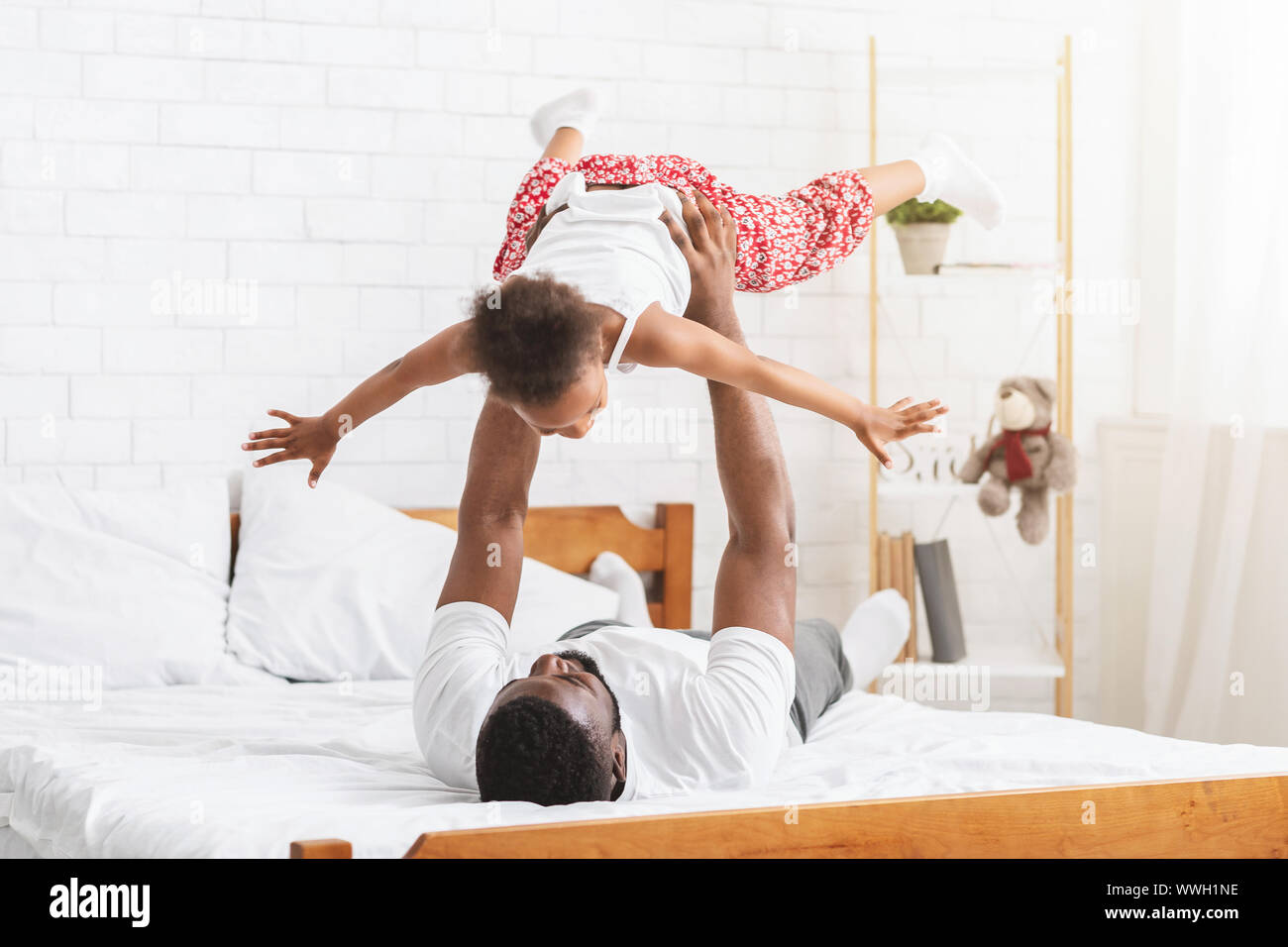 African man rising his little daughter up on legs Stock Photo - Alamy