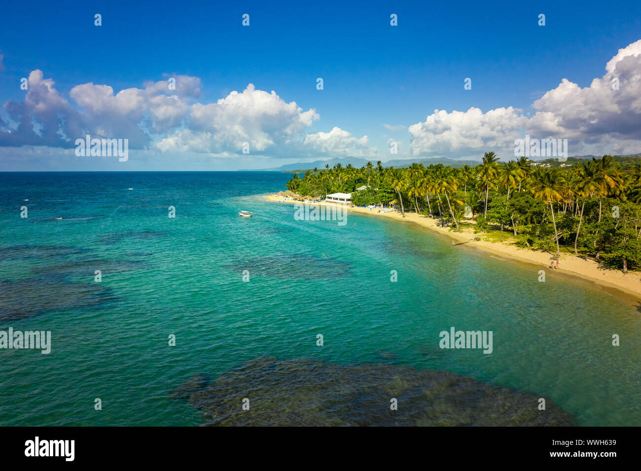 Aerial view of tropical beach with white boat anchored.Samana peninsula ...