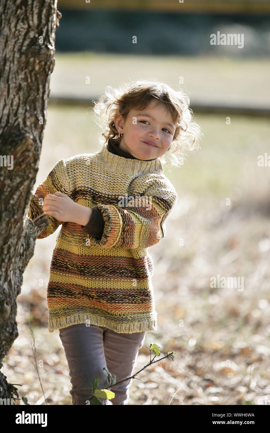 Young girl playing amongst the trees Stock Photo - Alamy