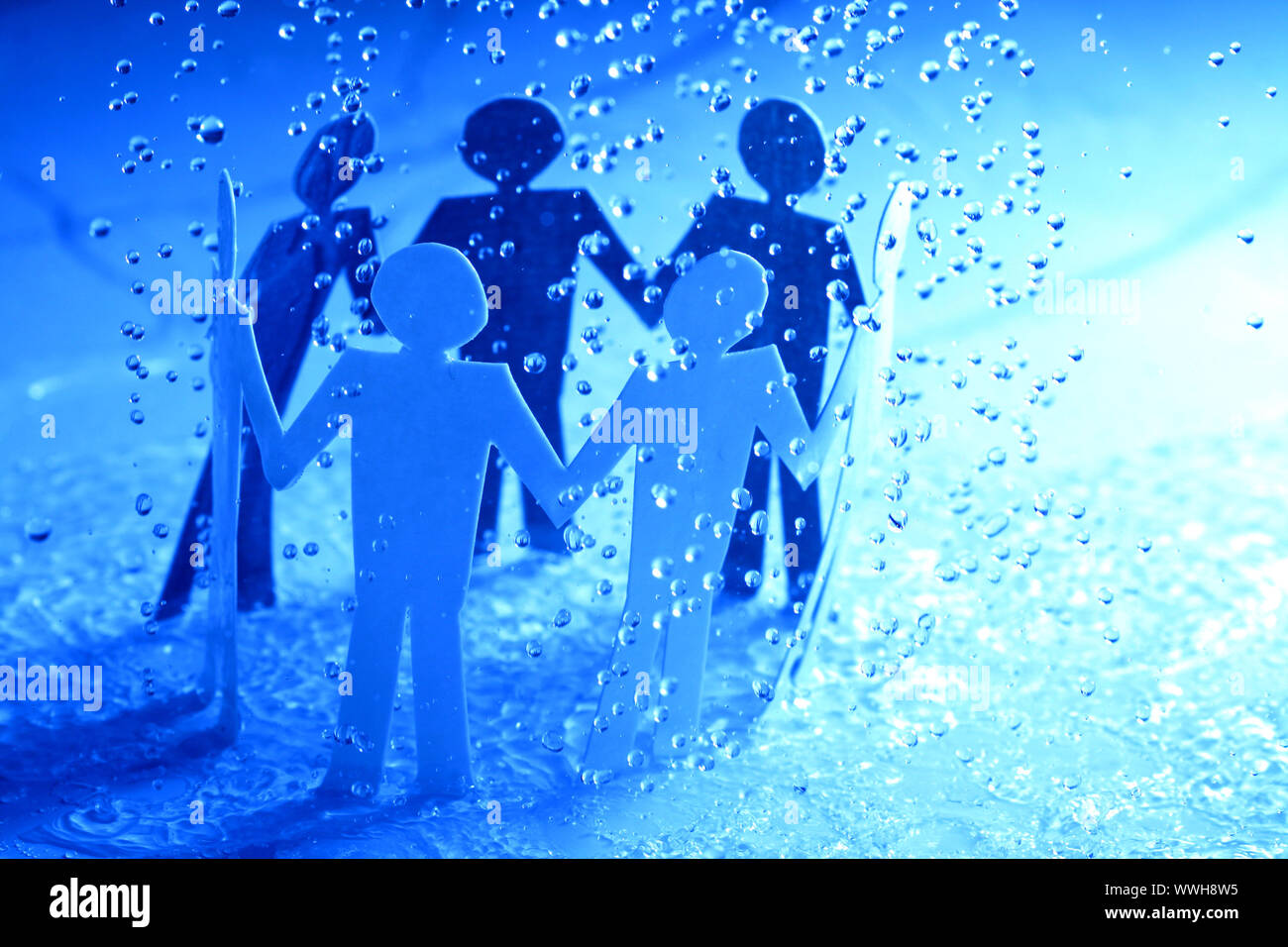 paper team linked together under rain weather concept Stock Photo - Alamy
