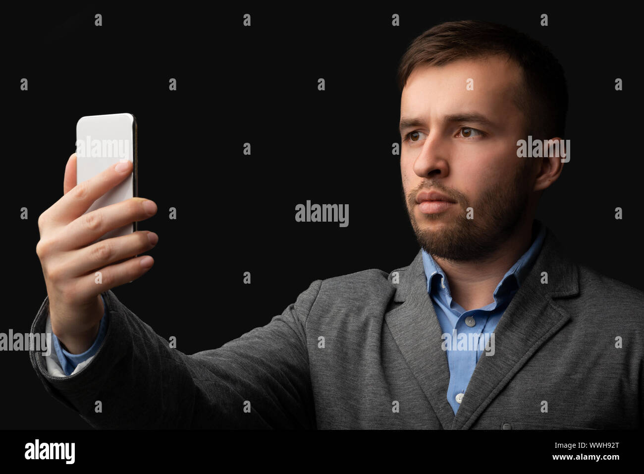 Young modern man in suit using facial recognition on smartphone Stock ...