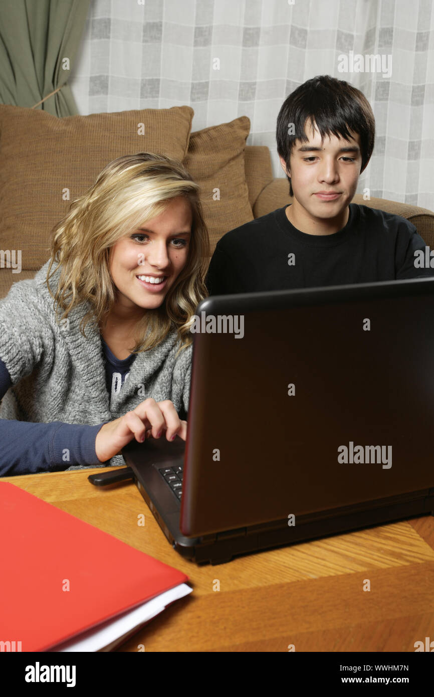 Two students and friends doing their homework using their laptop Stock ...