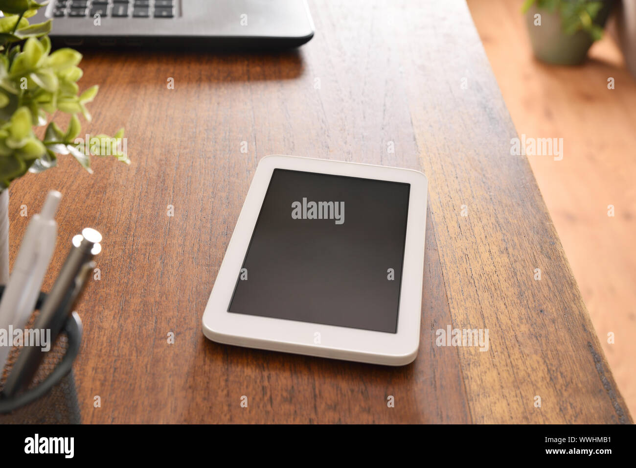 White tablet with blank screen on desk in office. Horizontal ...
