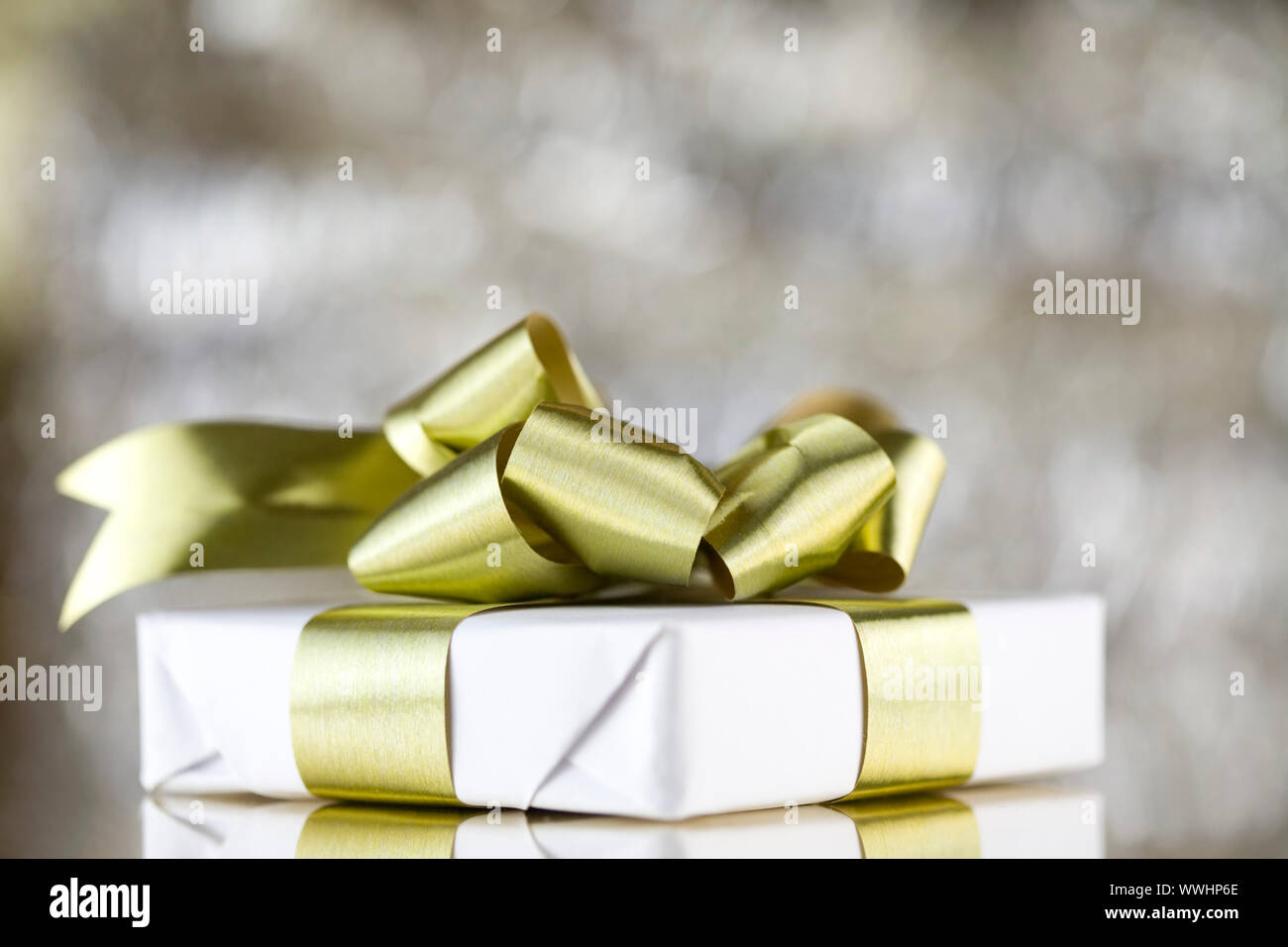 White present with gold ribbons Stock Photo - Alamy