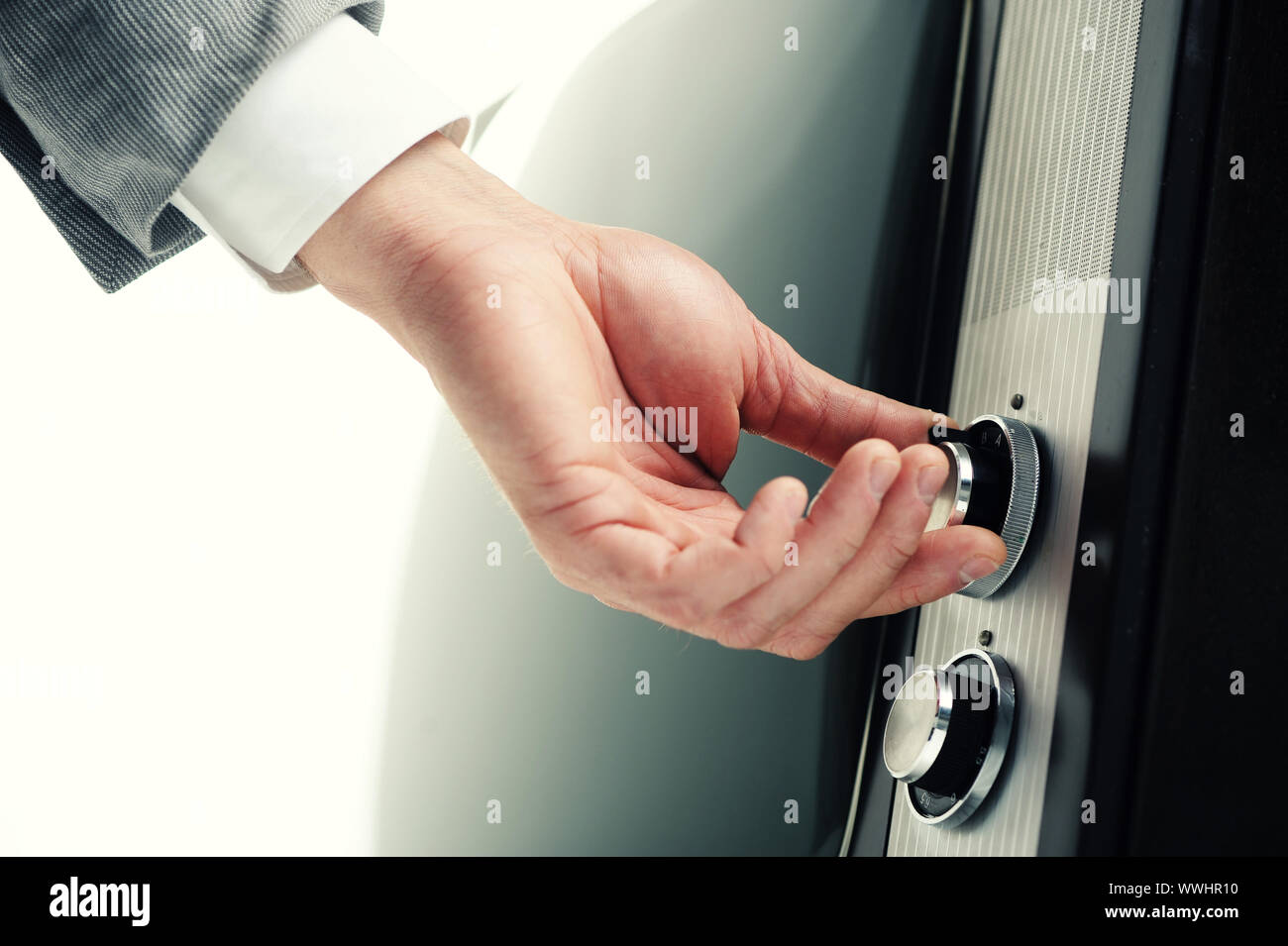 Man turning channel knob on retro television Stock Photo - Alamy