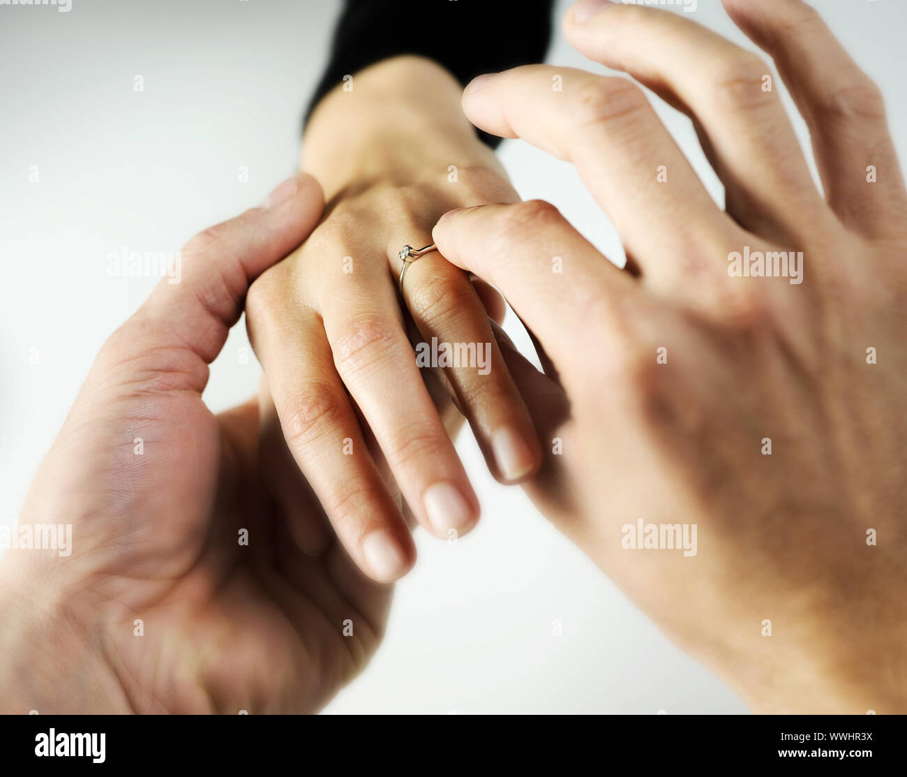 man putting a ring with a brilliant on a female hand, love concept ...