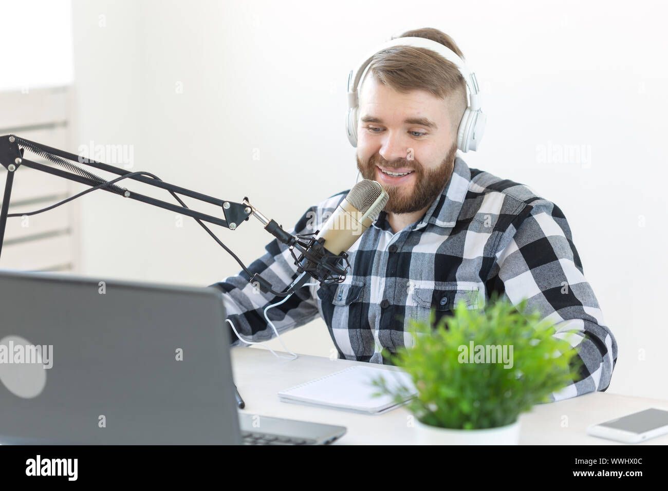 Blogging, music and broadcasting concept - young male dj at radio ...