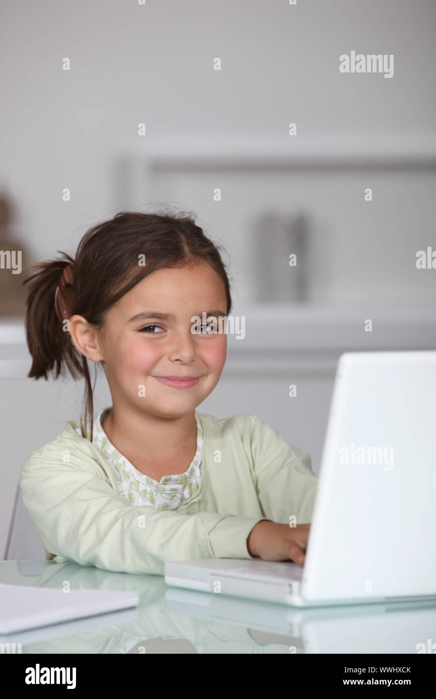 Little girl sat with laptop computer Stock Photo - Alamy