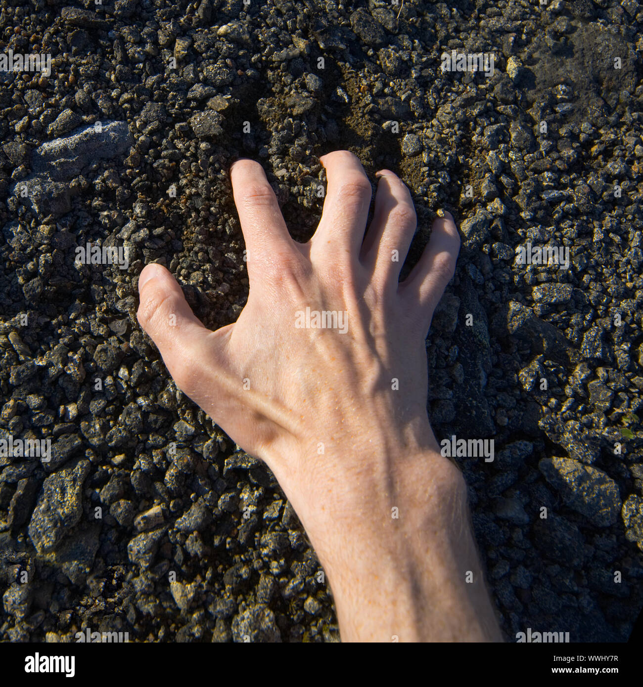 Man's hand clinging to a stony ground Stock Photo - Alamy