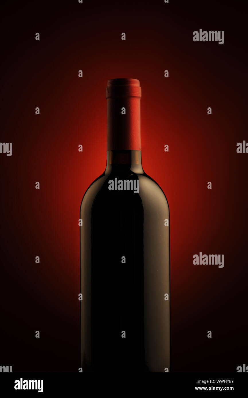 red wine bottle , red light on background Stock Photo - Alamy