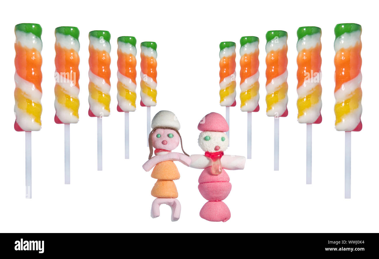 A couple of candy people in the middle of several lollipop sticks in a ...