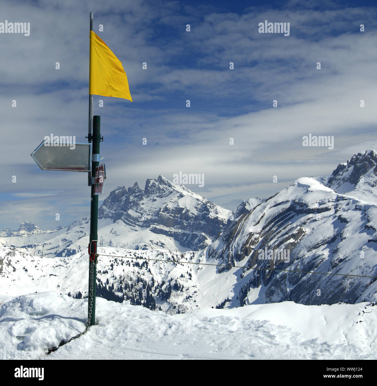 Yellow avalanche warning flag in the ski area Stock Photo - Alamy