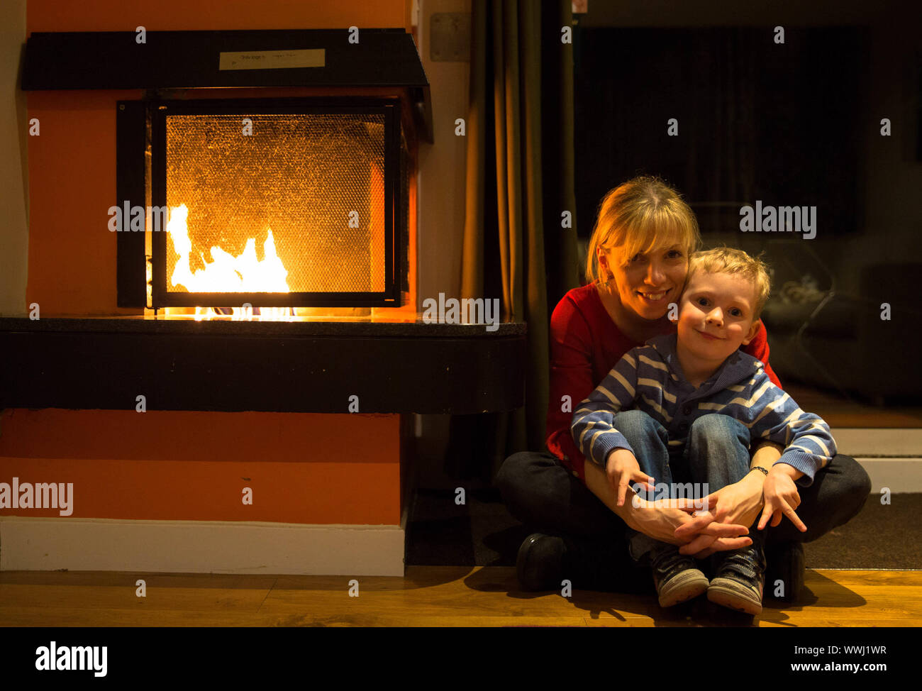 mother and son hugging by fire Stock Photo - Alamy