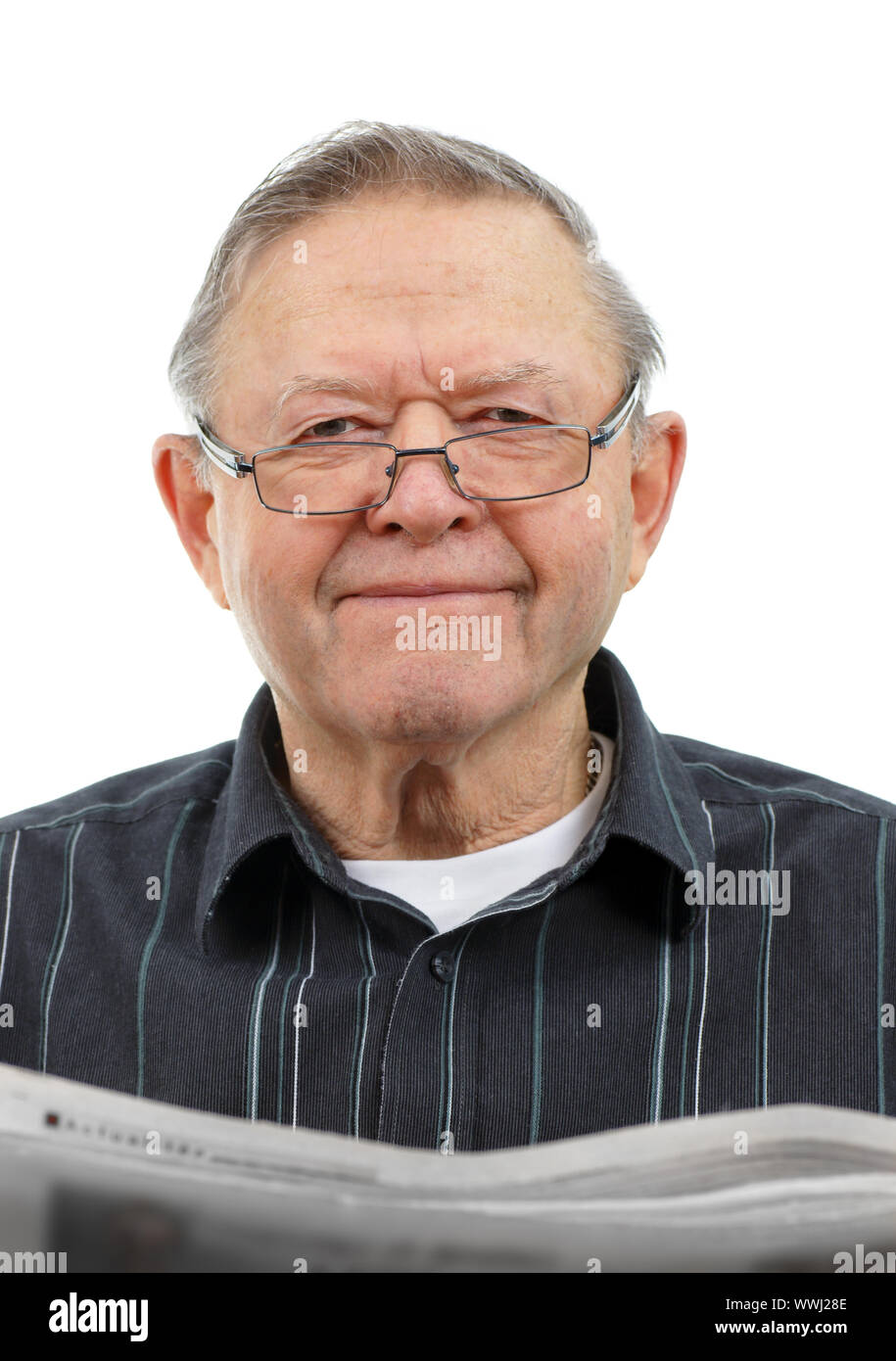 Happy senior man smiling looking up as he reads the morning's newspaper ...