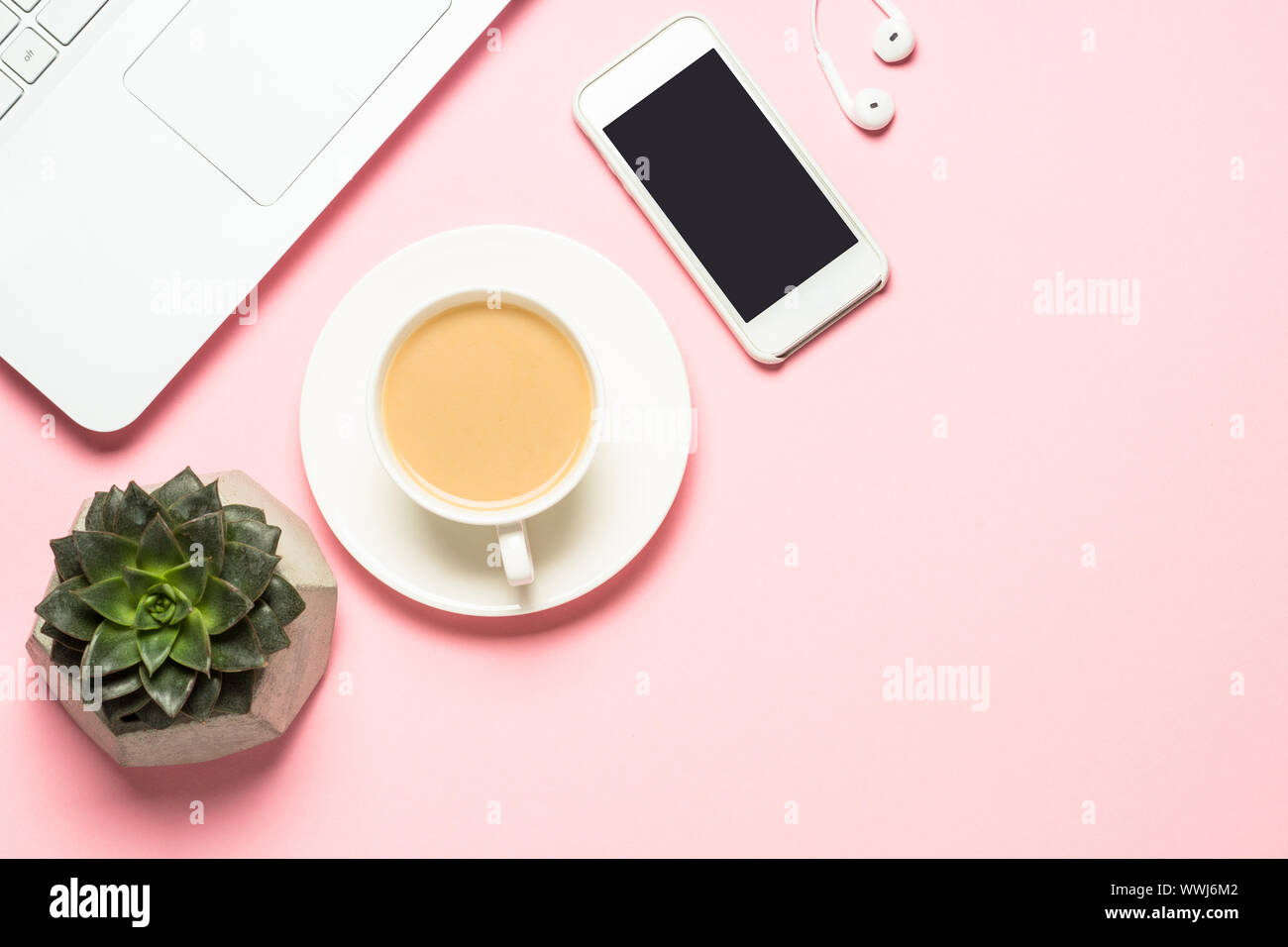 Office workplace with notepad, coffee cup and keyboard on pink ...