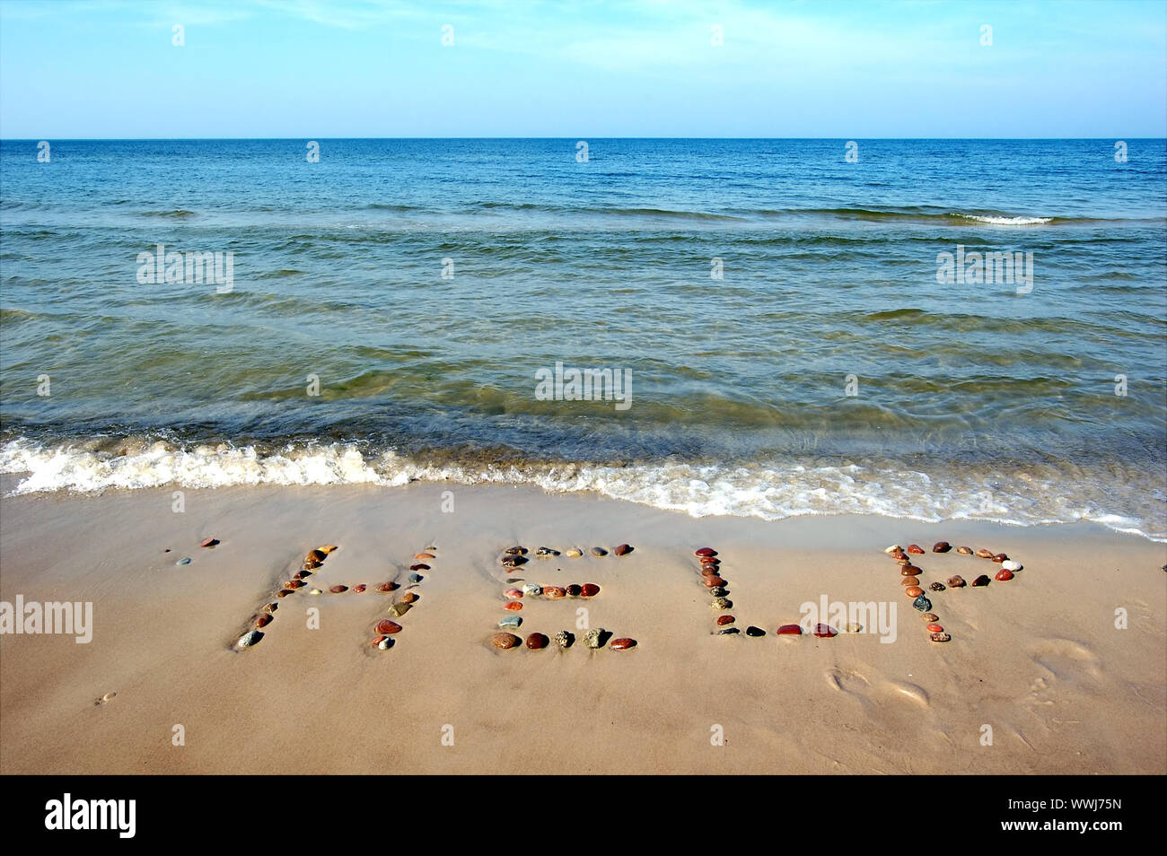 Word HELP on beach sand, made from rocks Stock Photo - Alamy