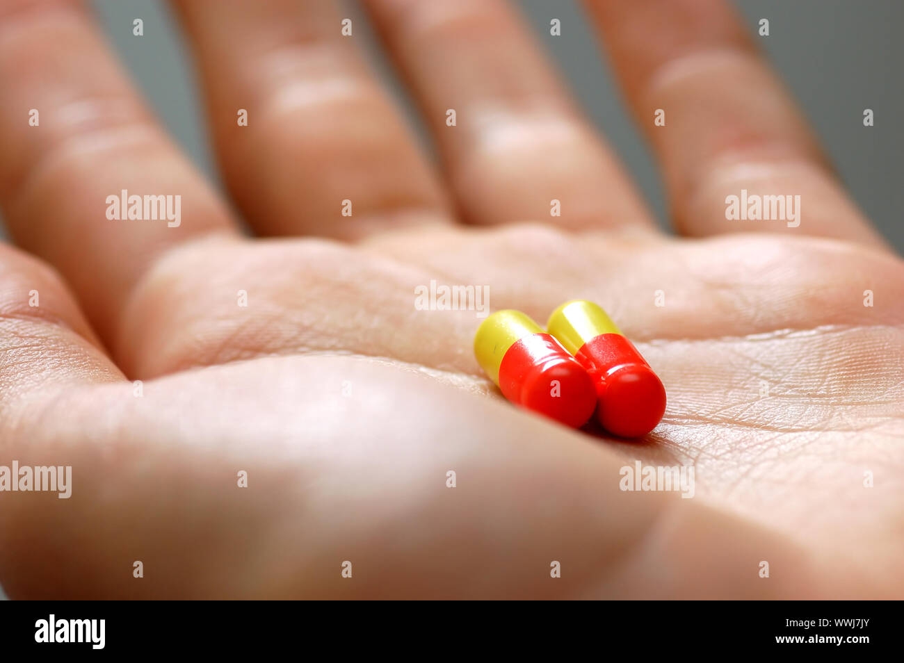 Taking pills. Hand with two capsules Stock Photo - Alamy