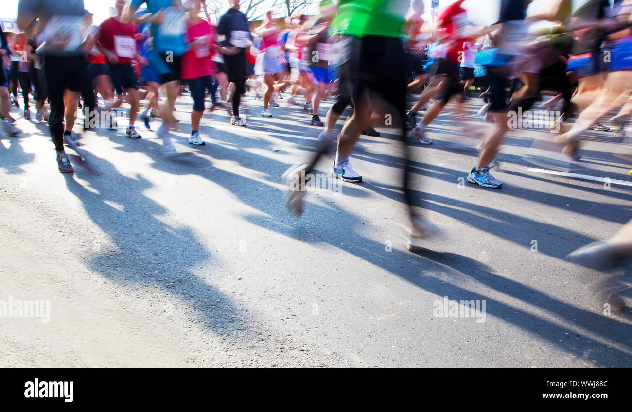 Running fast in marathon, legs close up. Sport, competition, energy ...