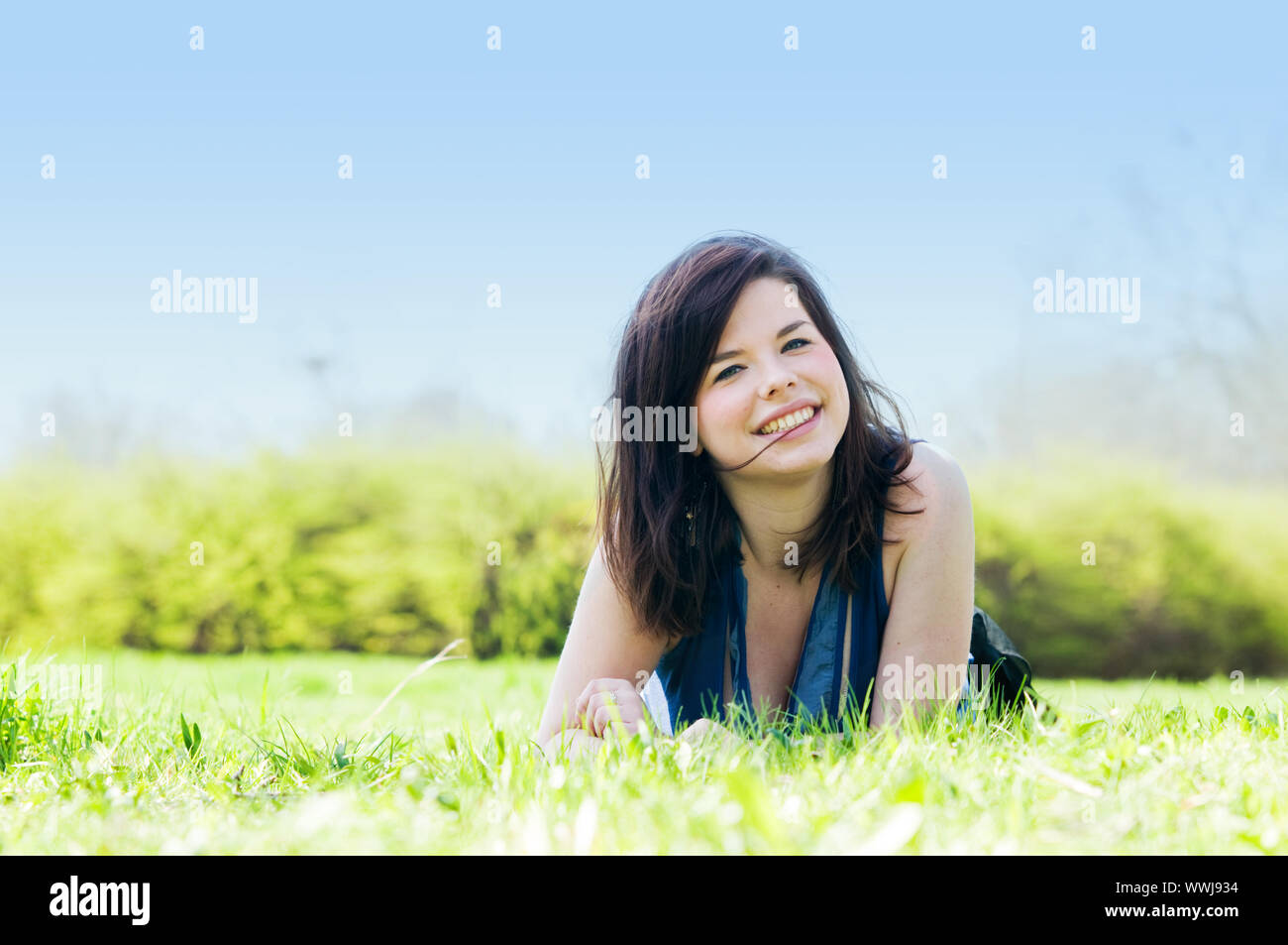 Young happy smiling girl lying on grass Stock Photo - Alamy