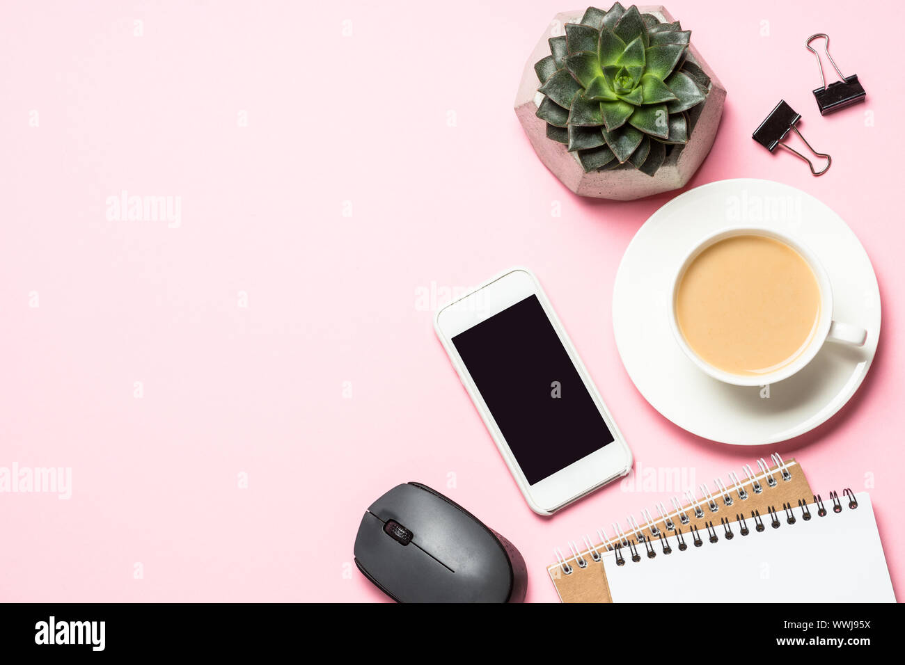 Office workplace with notepad, coffee cup and keyboard on pink ...