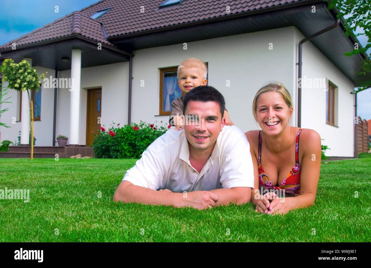 Happy family in front of their house Stock Photo - Alamy
