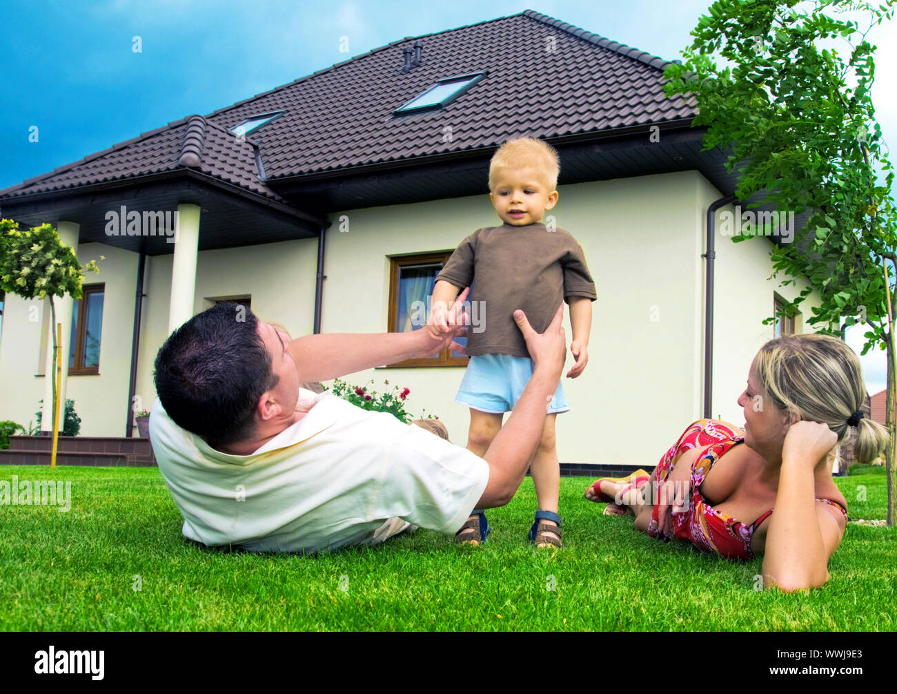 Happy family in front of their house Stock Photo - Alamy