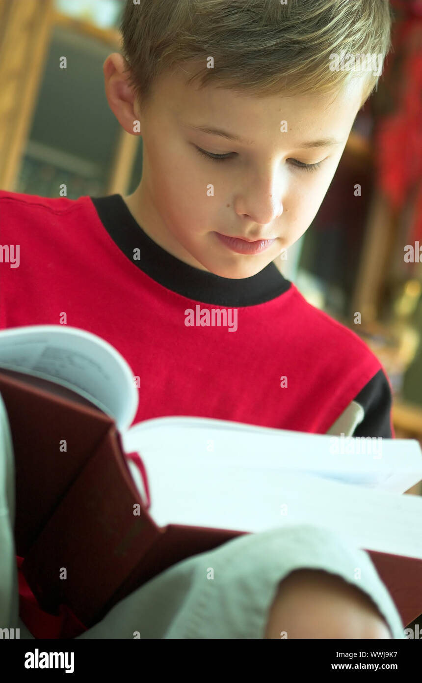 Young boy reading old, heavy book Stock Photo - Alamy