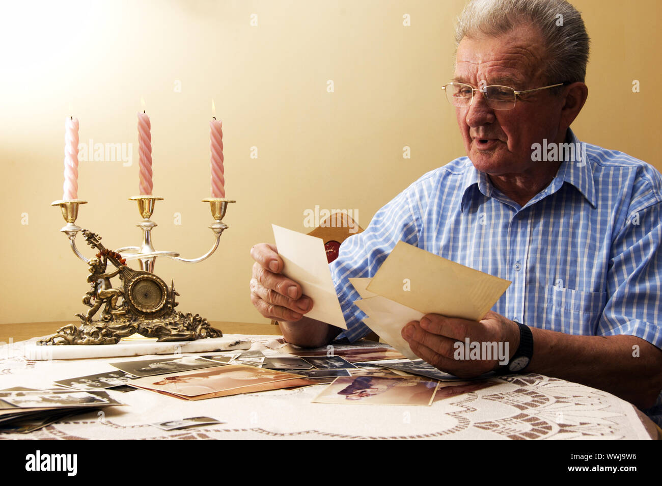 Senior man looking at old photographs. Reminisce about the past Stock ...