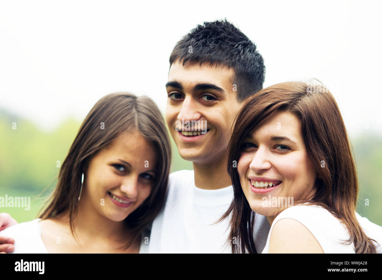 Three young happy friends standing together and smiling Stock Photo - Alamy