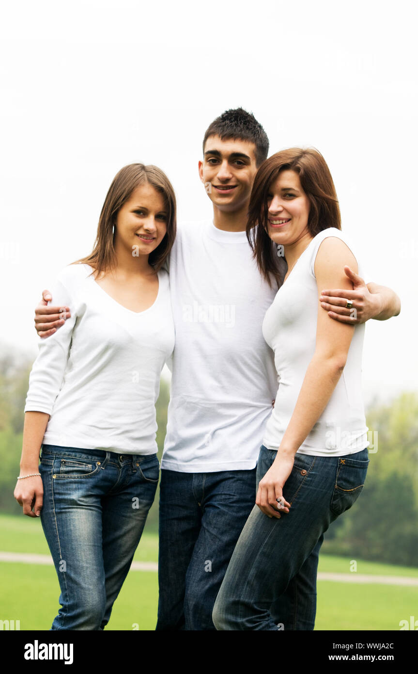 Three young happy friends standing together and smiling Stock Photo - Alamy