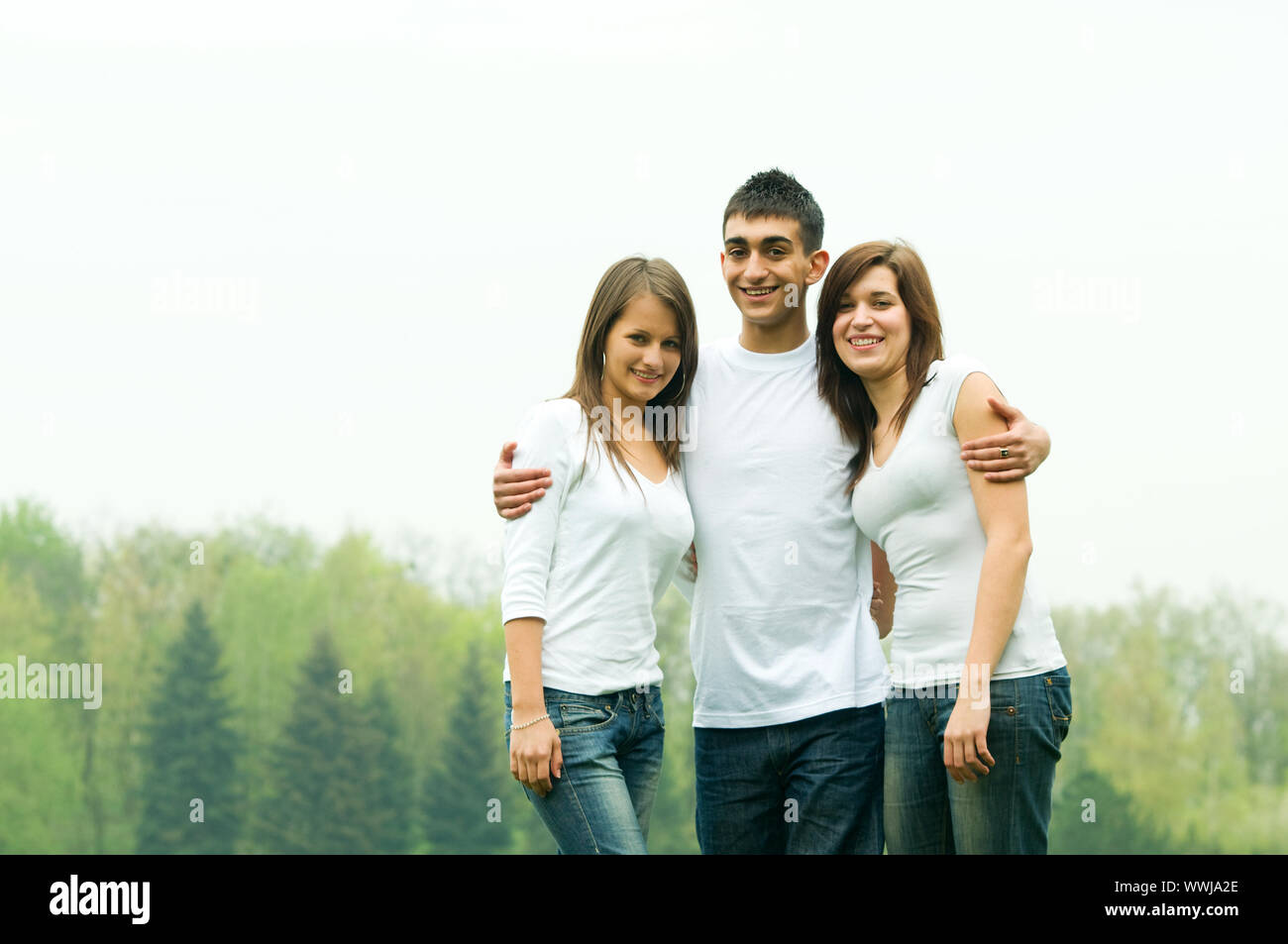 Three young happy friends standing together and smiling Stock Photo - Alamy