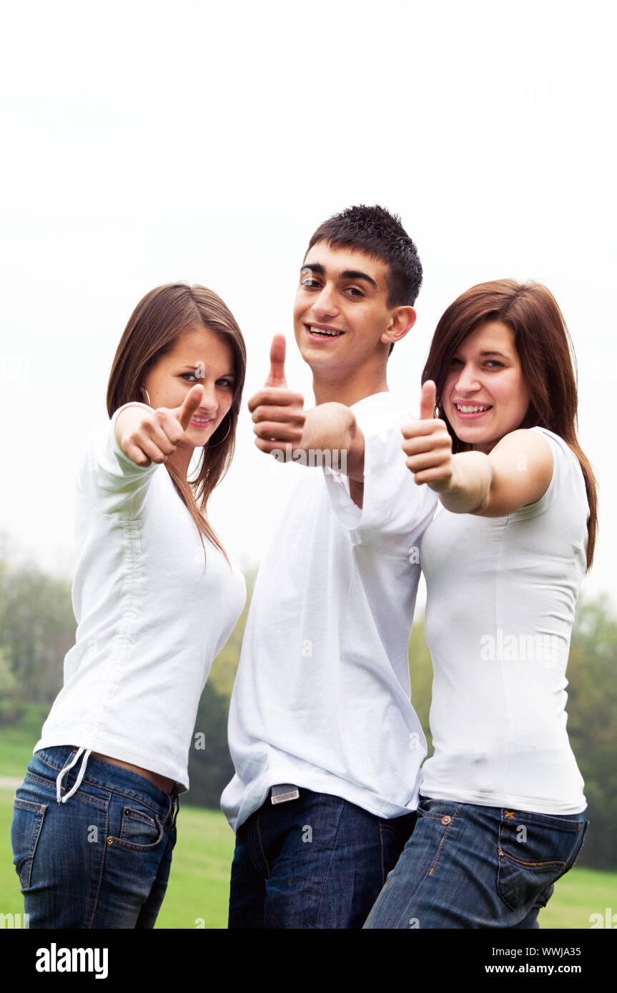 Three young happy friends laughing and giving okey sing Stock Photo - Alamy