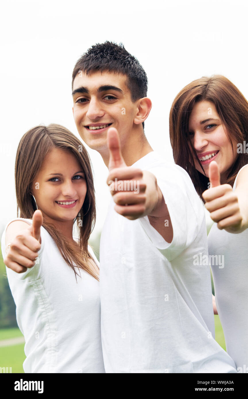 Three young happy friends laughing and giving okey sing Stock Photo - Alamy