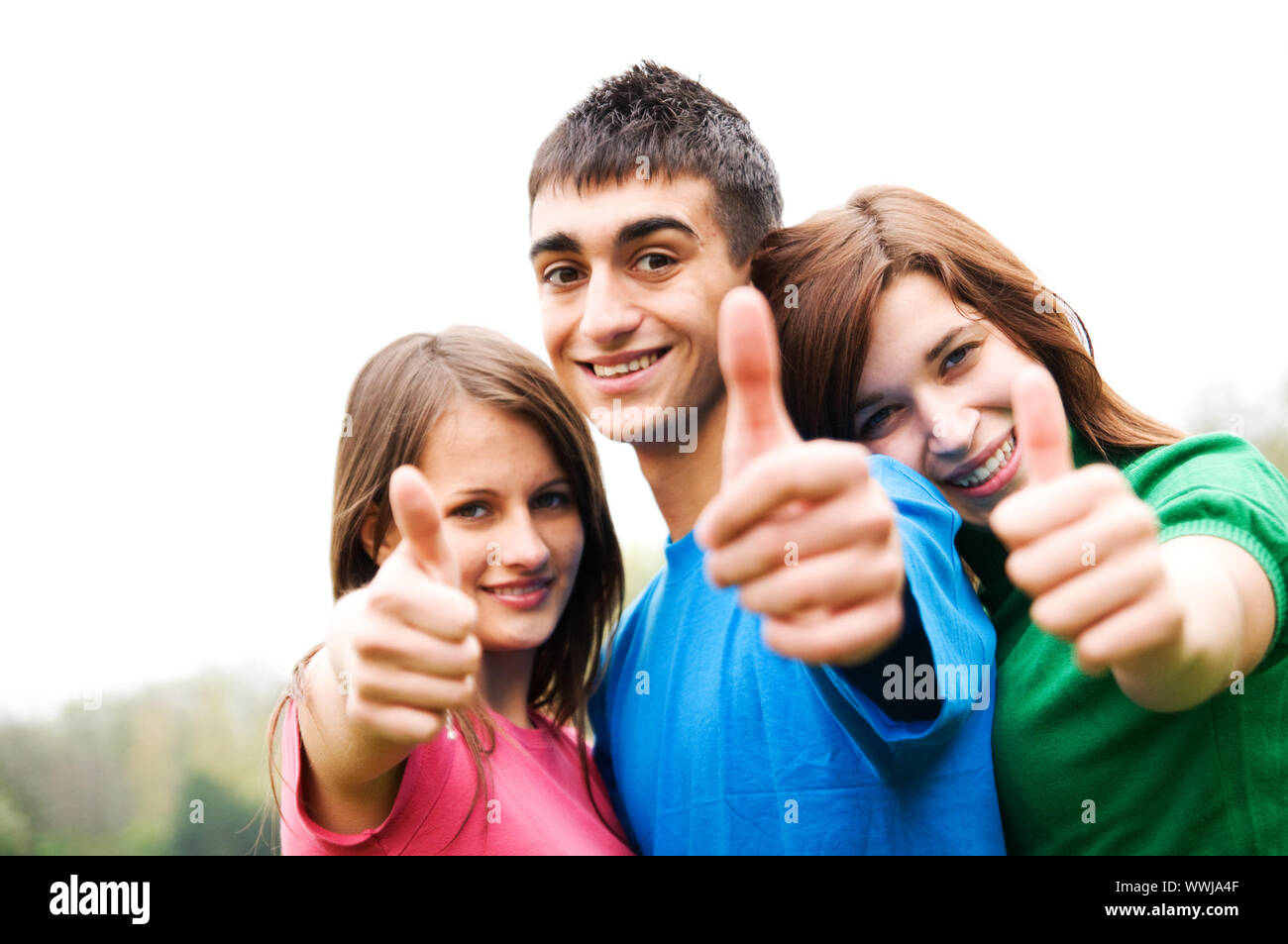Three young happy friends laughing and giving okey sing Stock Photo - Alamy