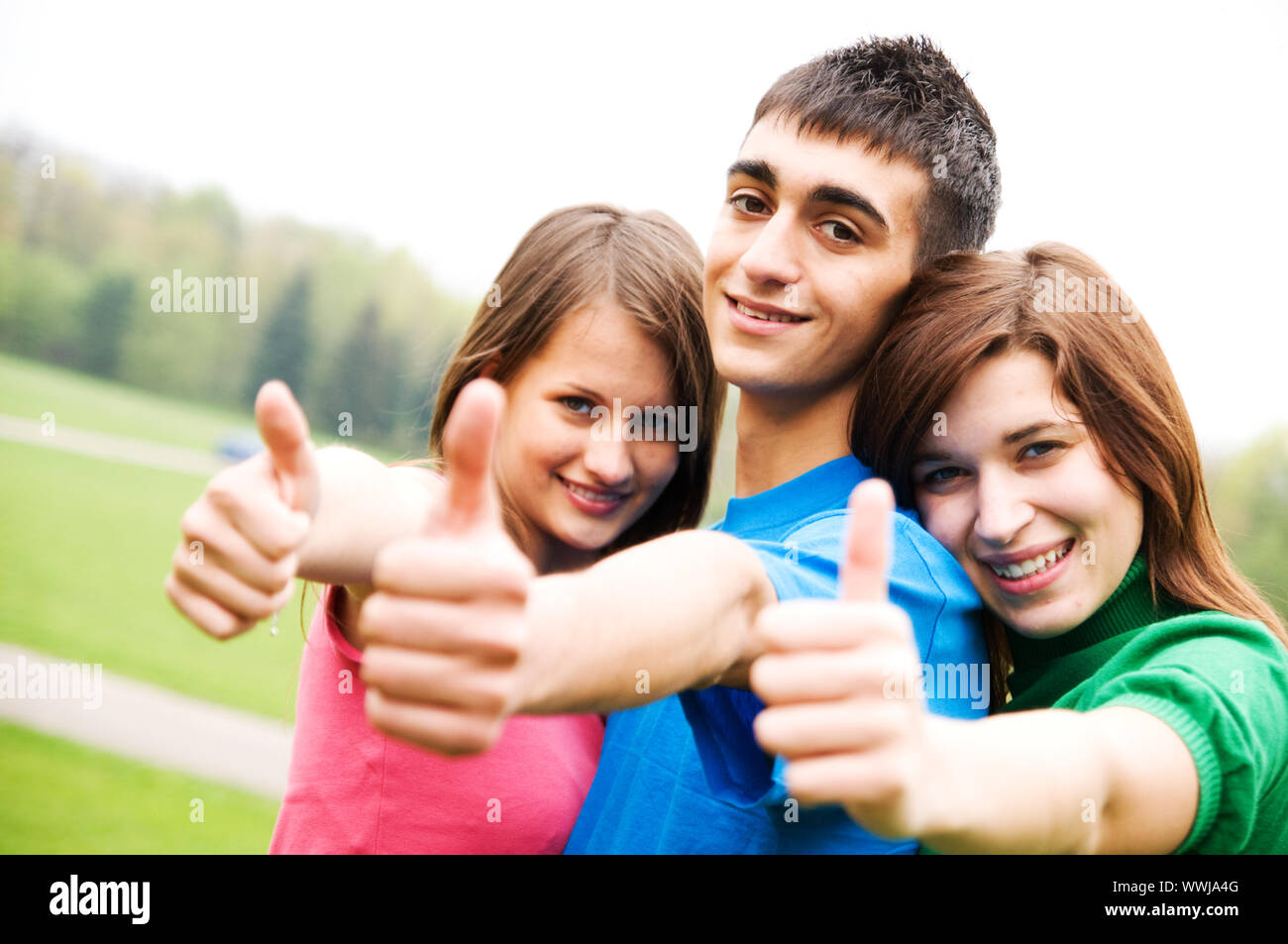 Three young happy friends laughing and giving okey sing Stock Photo - Alamy