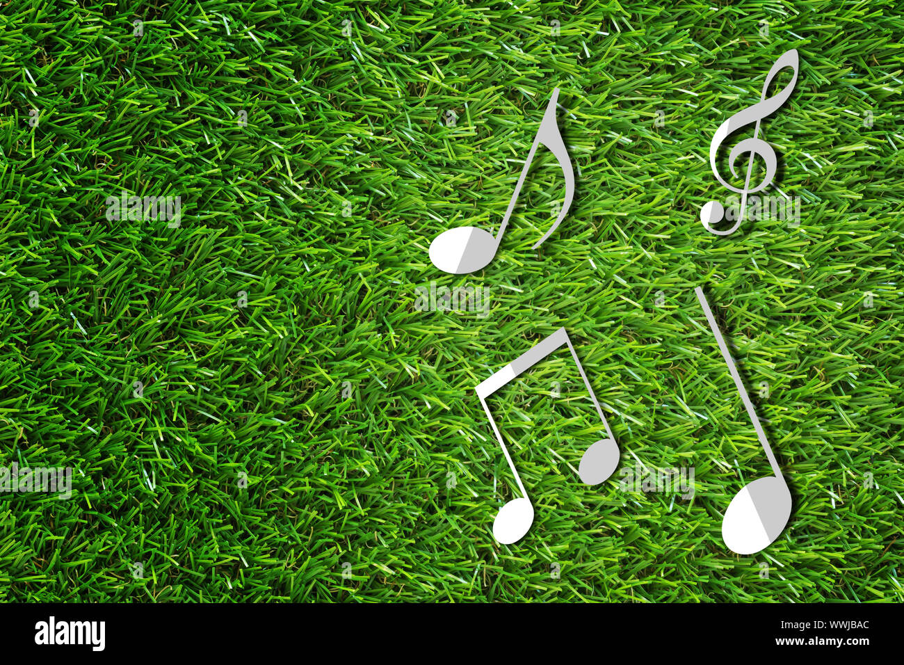 Music note concept on green grass background Stock Photo - Alamy