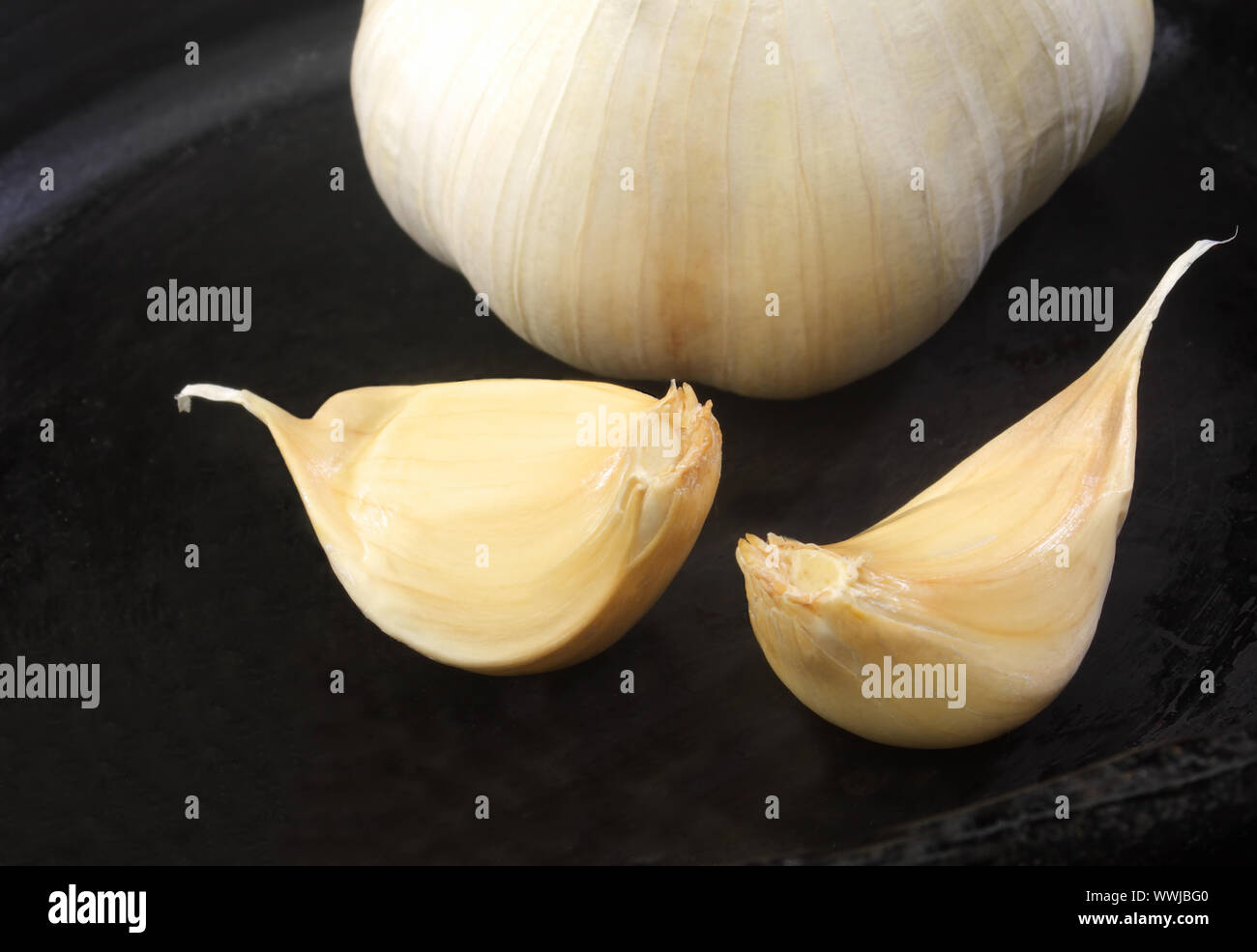 Whole head and cloves of garlic on black background Stock Photo - Alamy