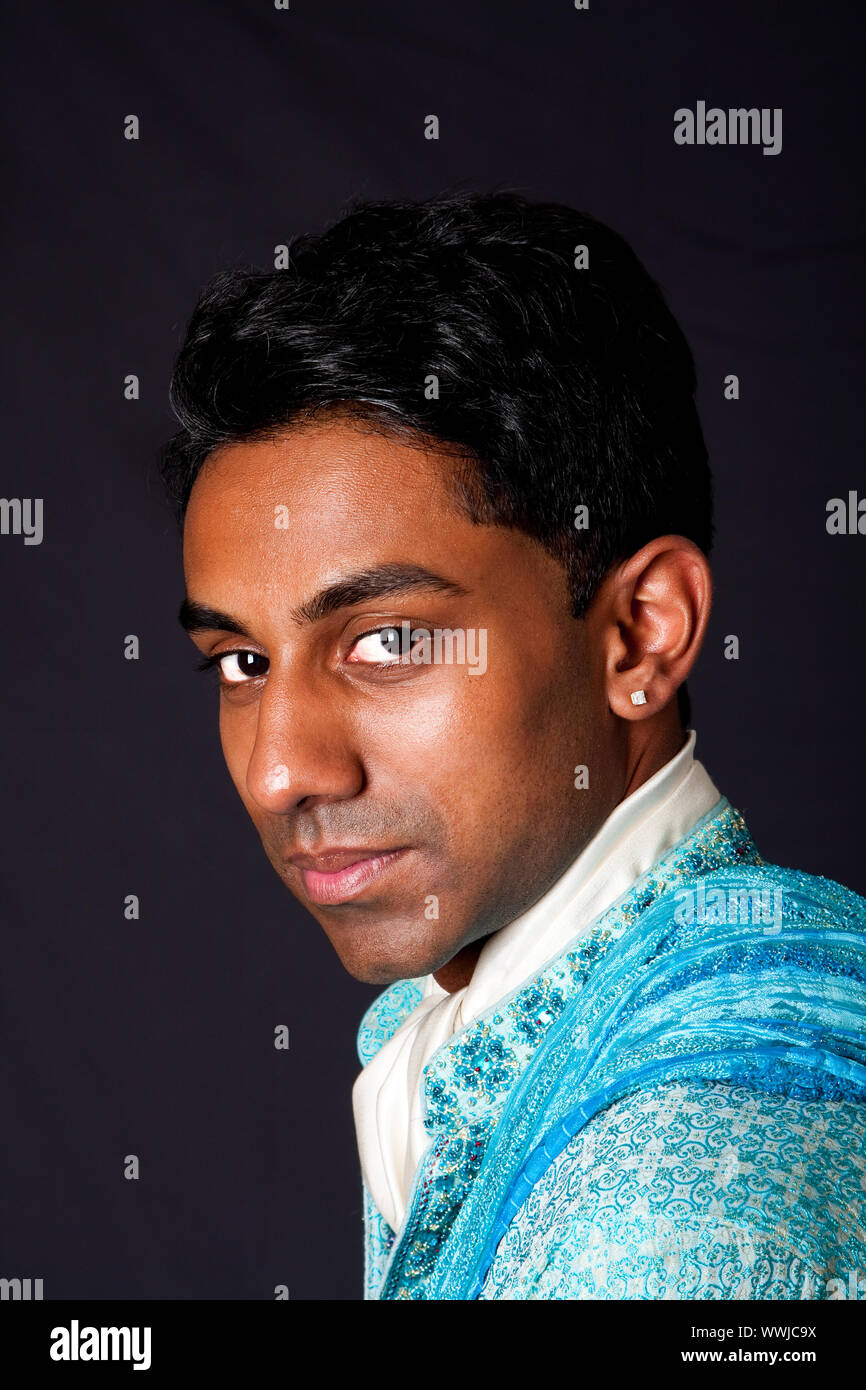 Beautiful face of an Indian Hindu young man with earring wearing blue ...